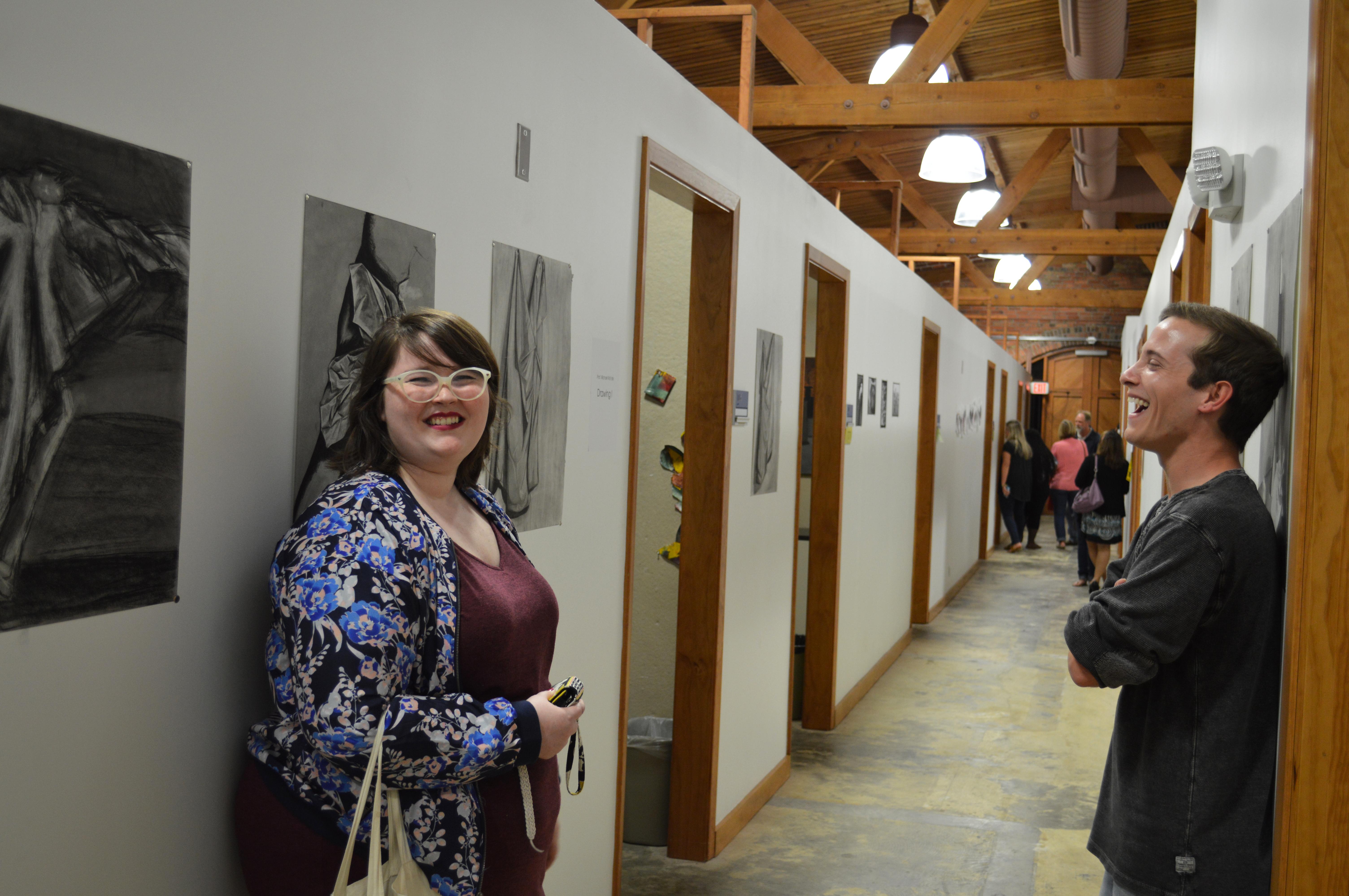 Two students laughing in a hallway