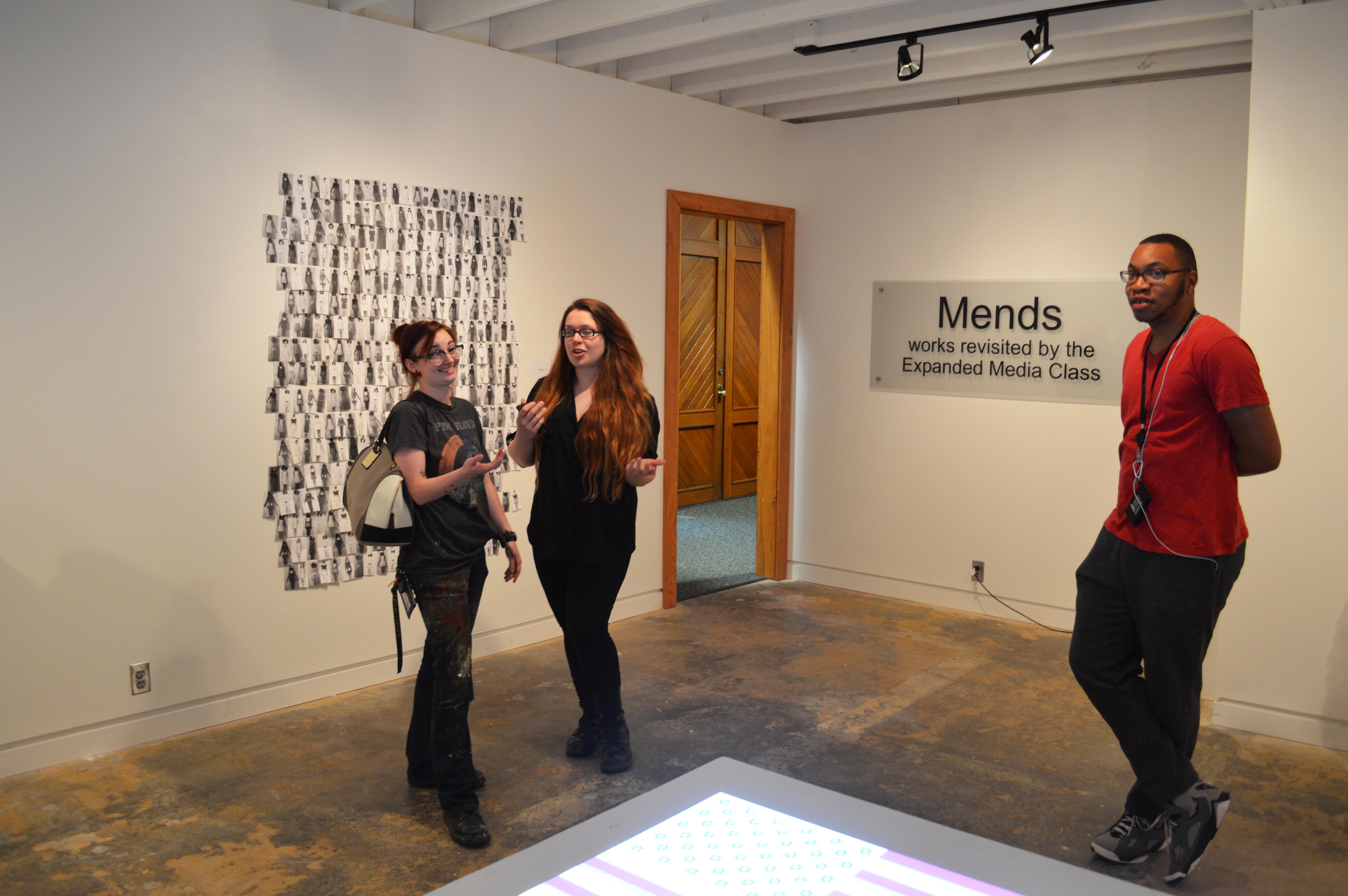 Three people in an art gallery